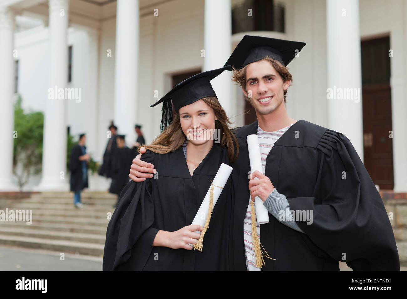 Graduates with their degrees on campus Stock Photo - Alamy