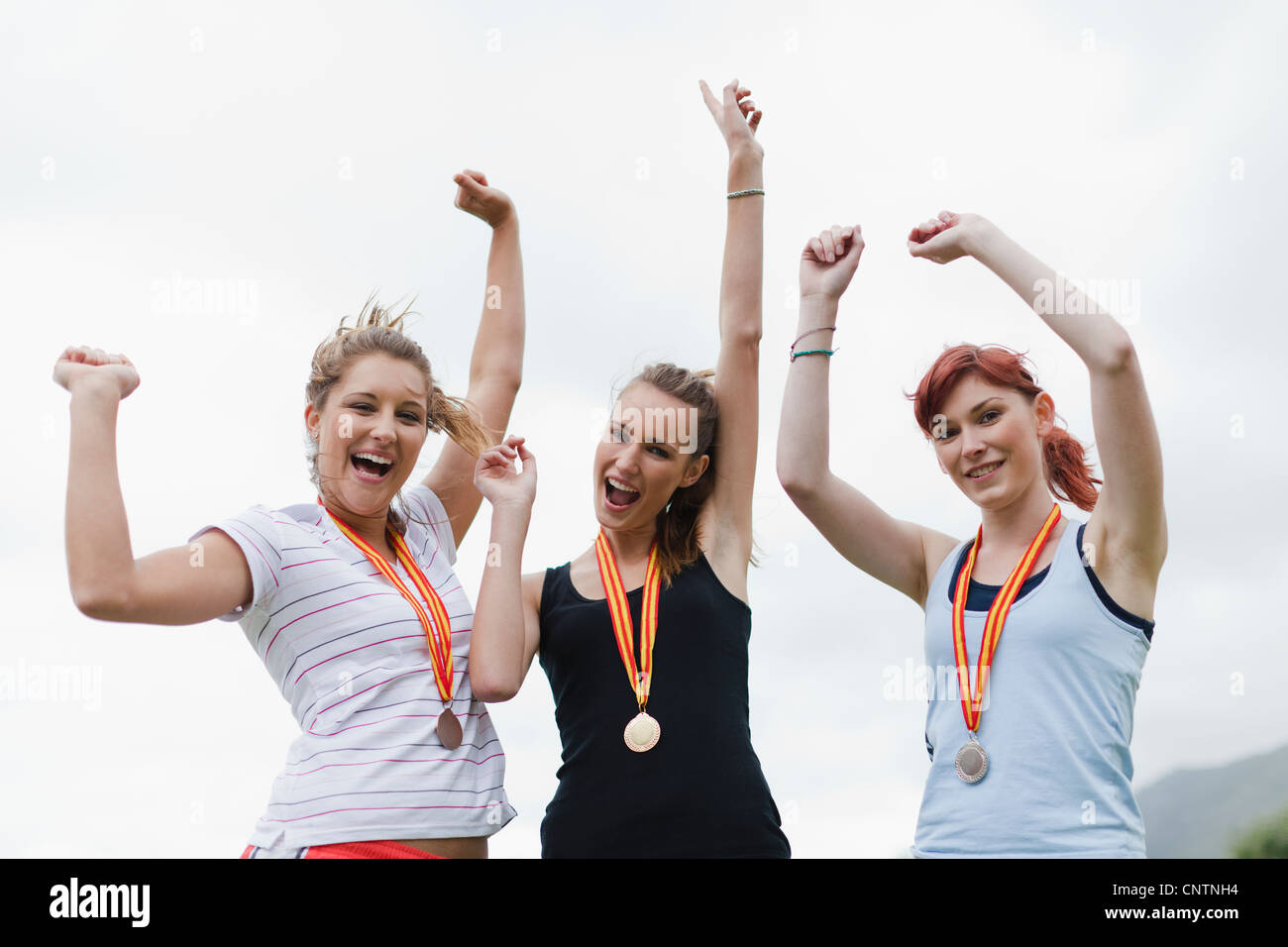 Cheering women wearing medals in park Stock Photo - Alamy