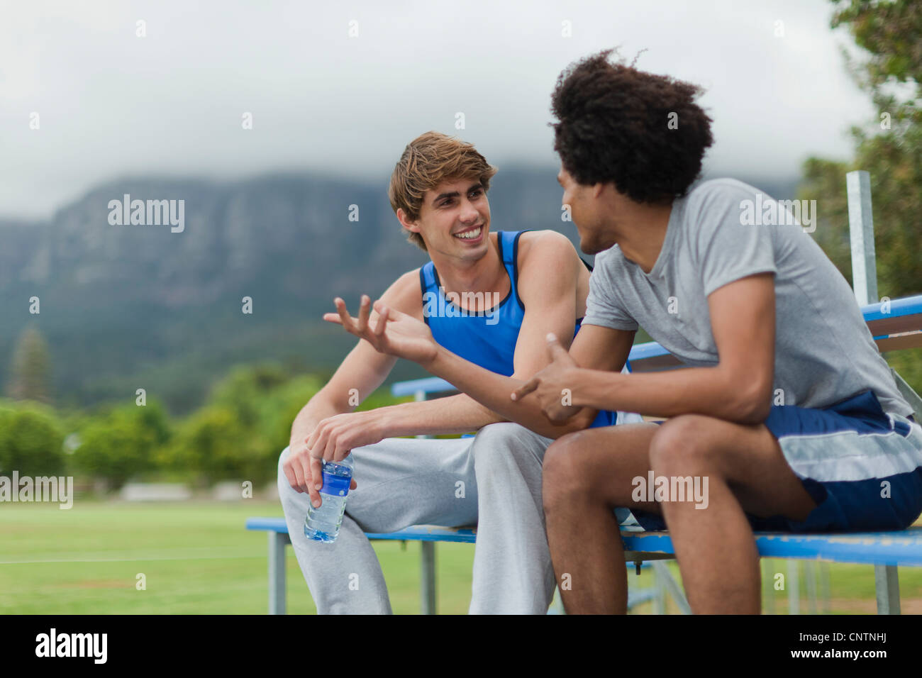Men talking on bleachers in park Stock Photo - Alamy