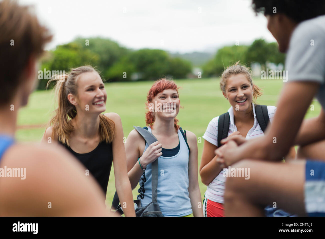 Friends talking in park Stock Photo - Alamy