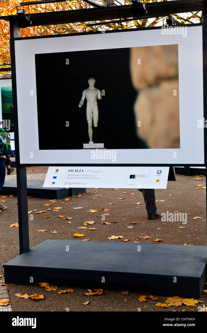 One legged man behind a photograph of the 5th century statue of Ephebe ...