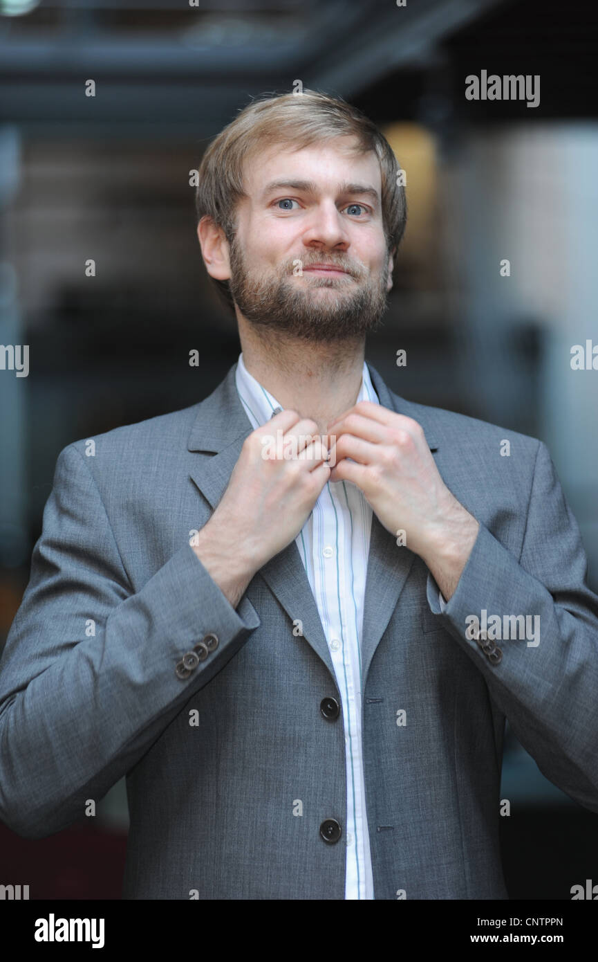 Businessman adjusting his collar Stock Photo - Alamy