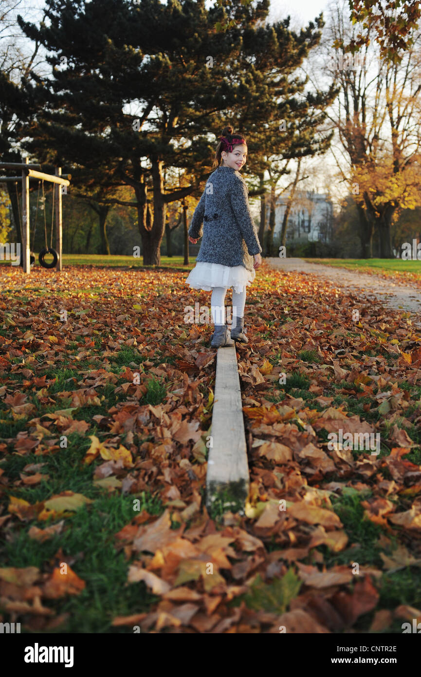 Girl playing on balance in park Stock Photo - Alamy
