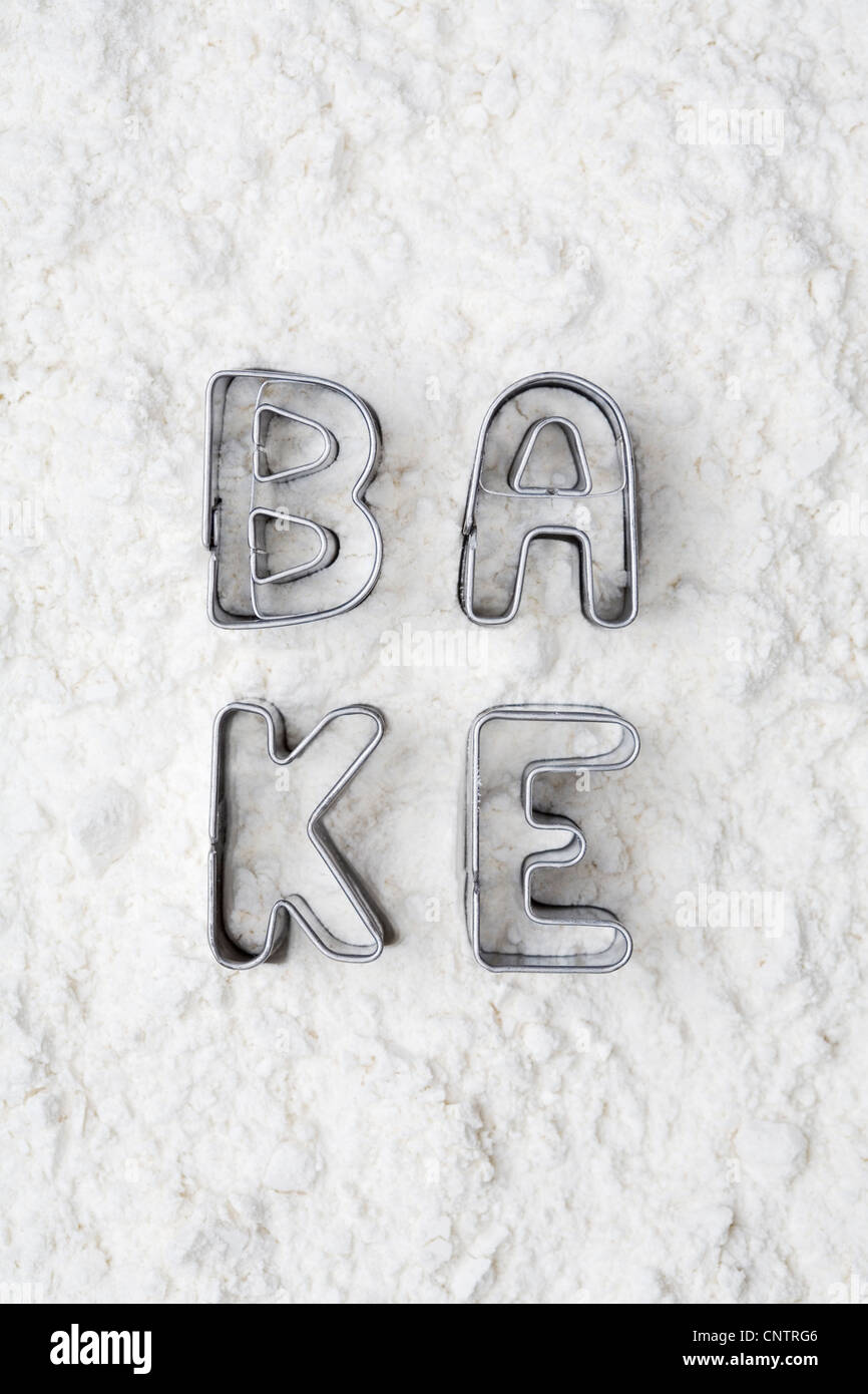 Cookie cutters spelling bake in flour Stock Photo - Alamy