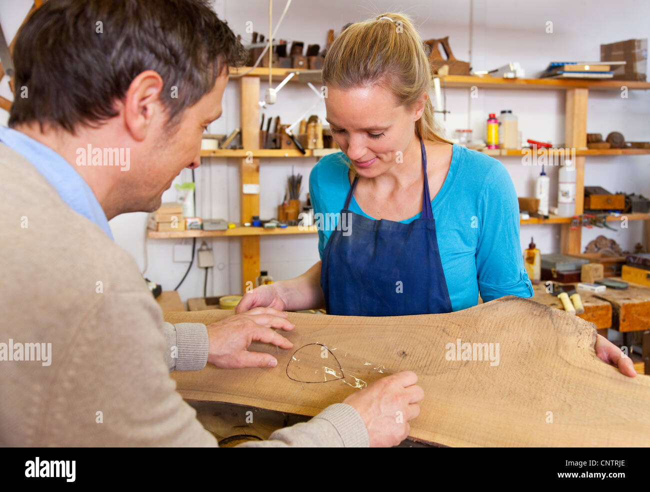 Carpenter and assistant working in shop Stock Photo - Alamy