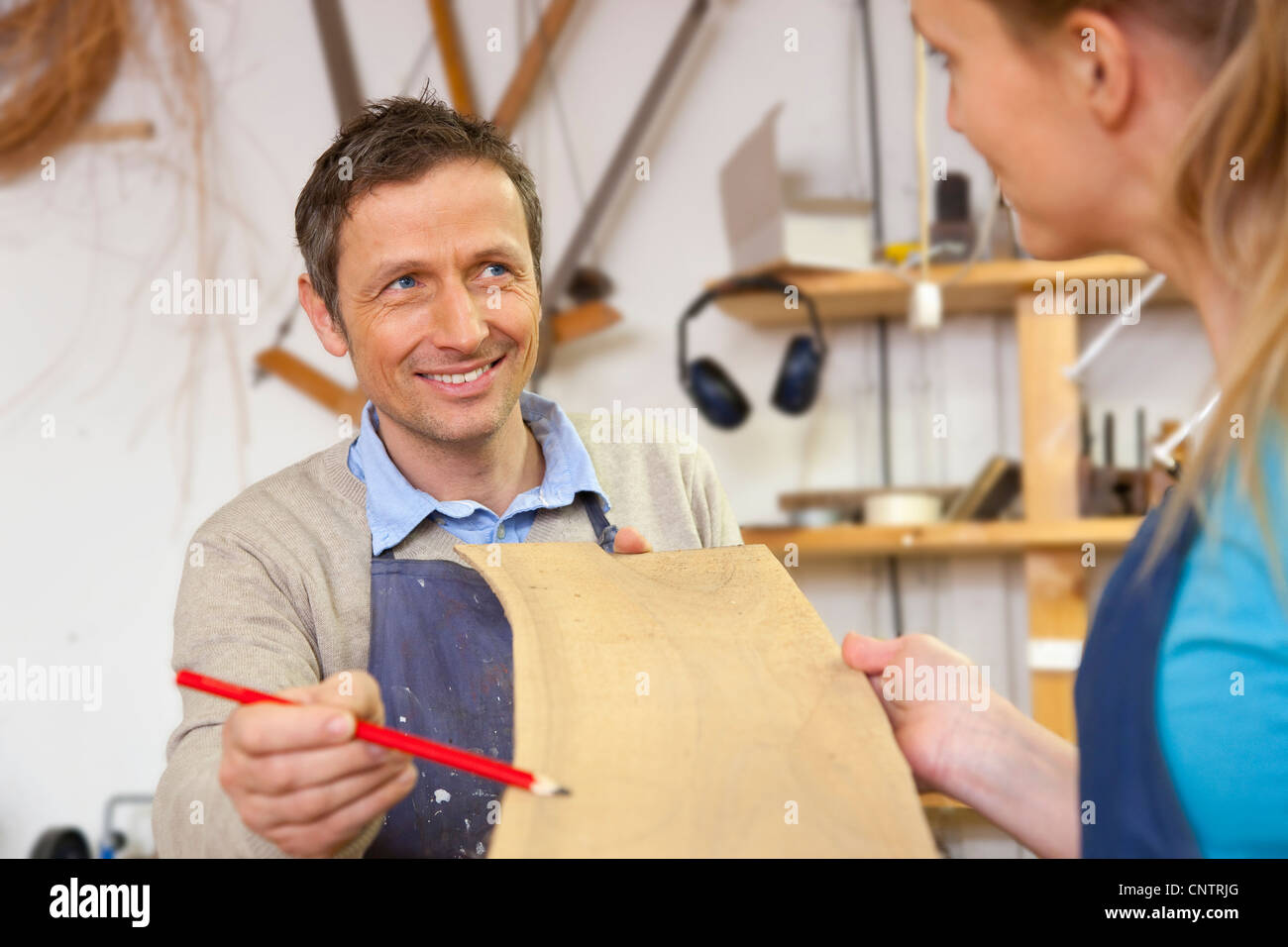 Carpenter giving blueprints to assistant Stock Photo - Alamy