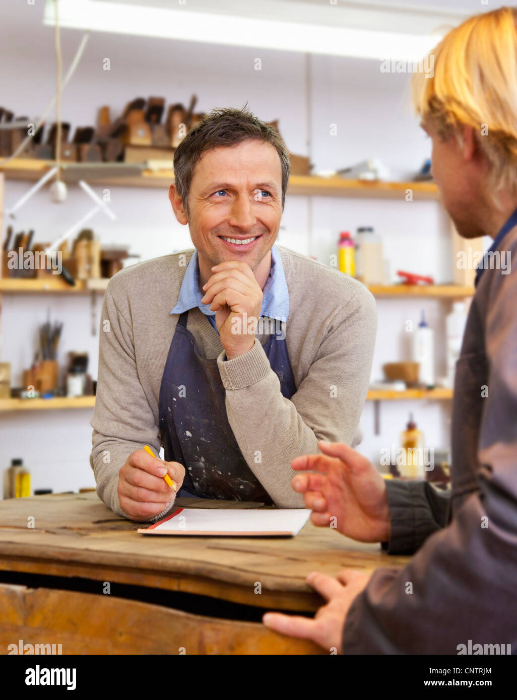 Carpenter working with client in shop Stock Photo - Alamy