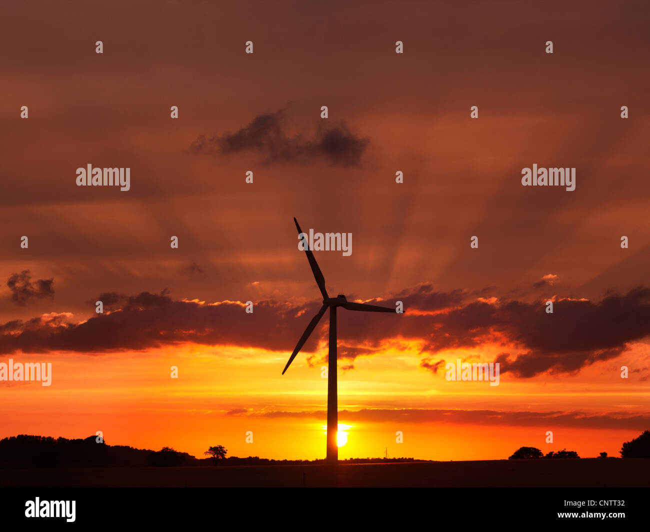 Wind turbine against sunset sky Stock Photo - Alamy