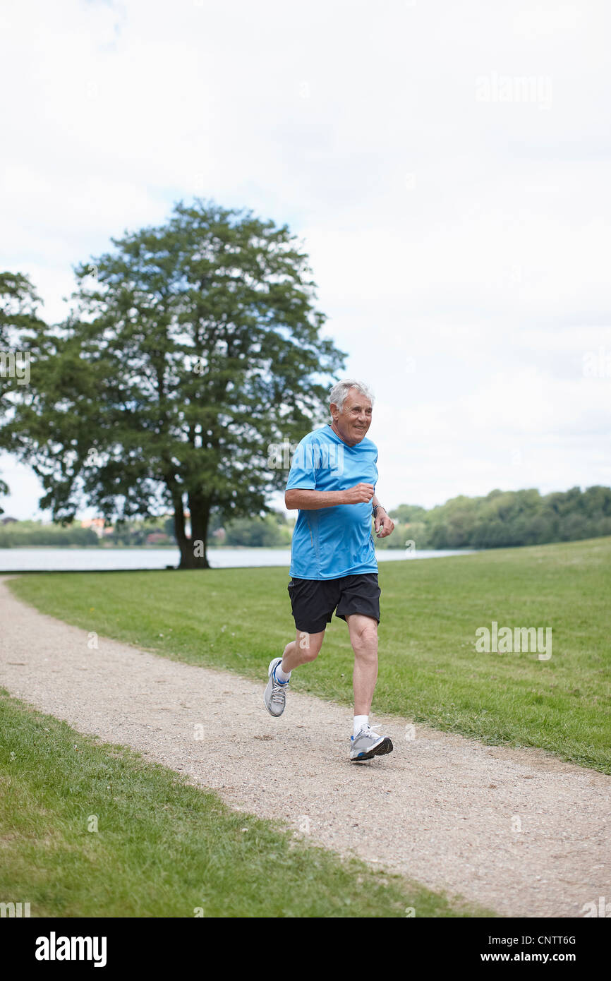 Older man jogging on dirt path Stock Photo - Alamy