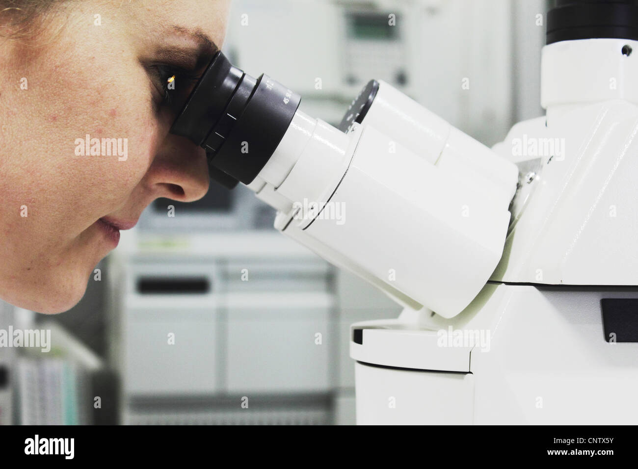 Scientist looking through microscope Stock Photo - Alamy