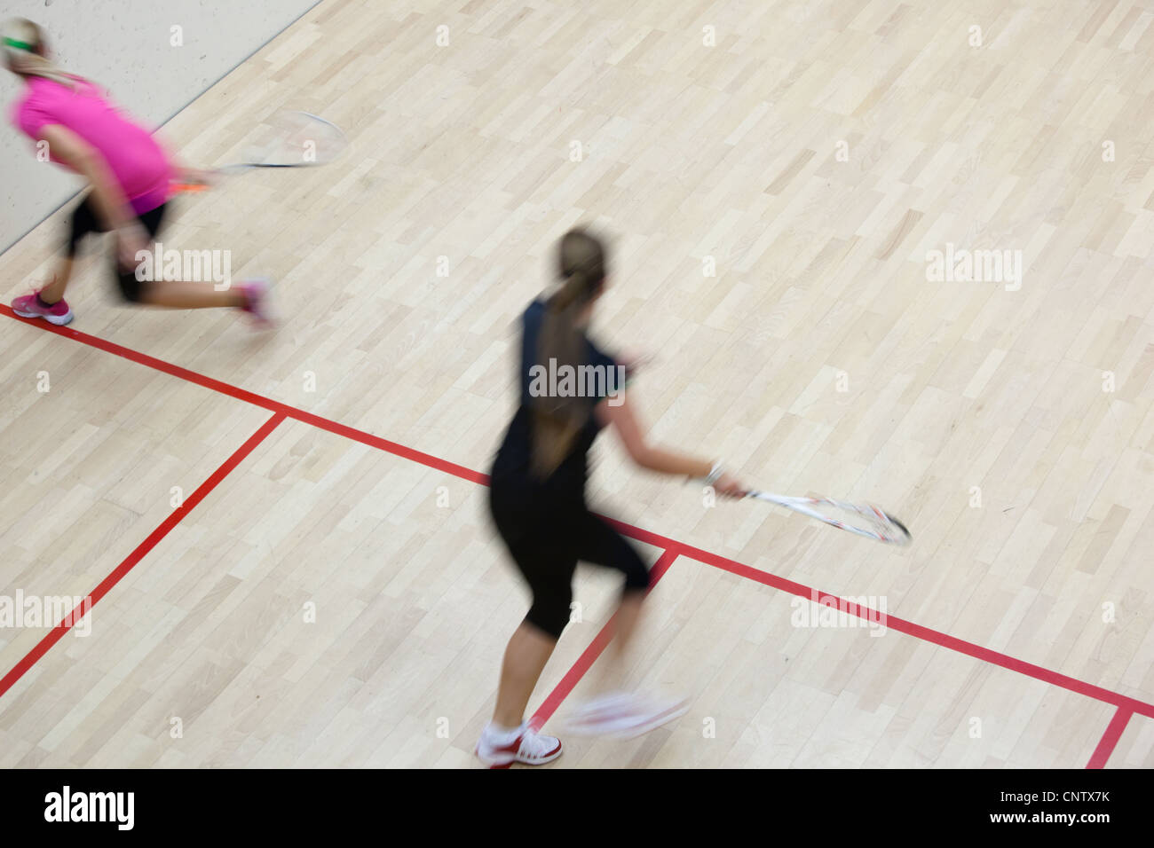 Two female squash players in fast action on a squash court (motion ...