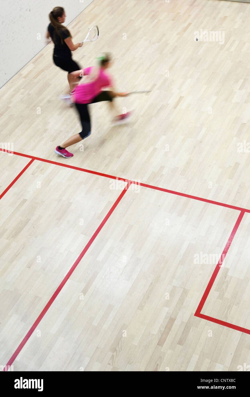 Two female squash players in fast action on a squash court (motion ...