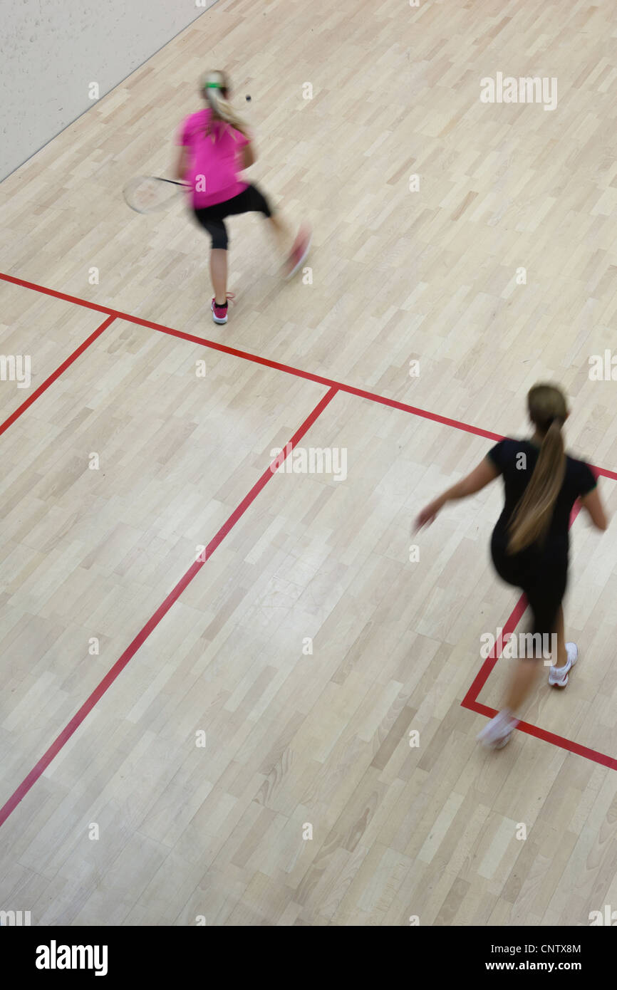 Two female squash players in fast action on a squash court (motion ...