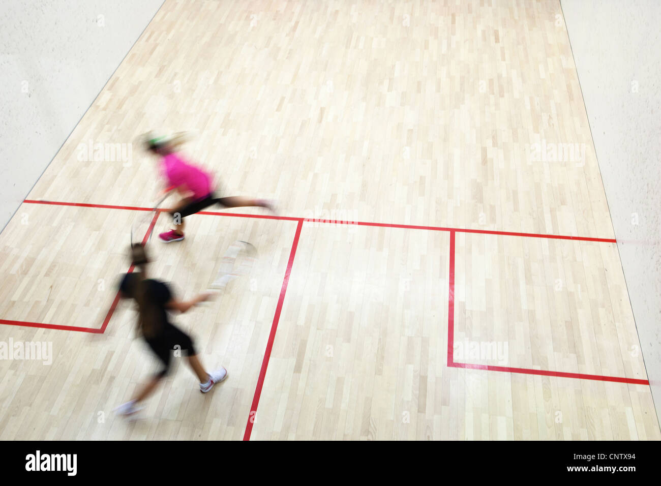 Two female squash players in fast action on a squash court (motion ...