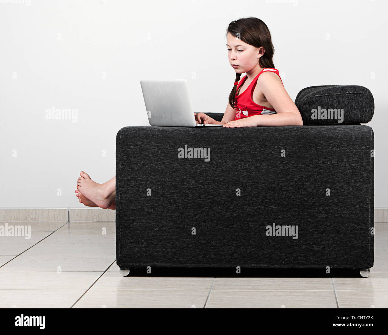 Girl on Laptop on Sofa Stock Photo - Alamy