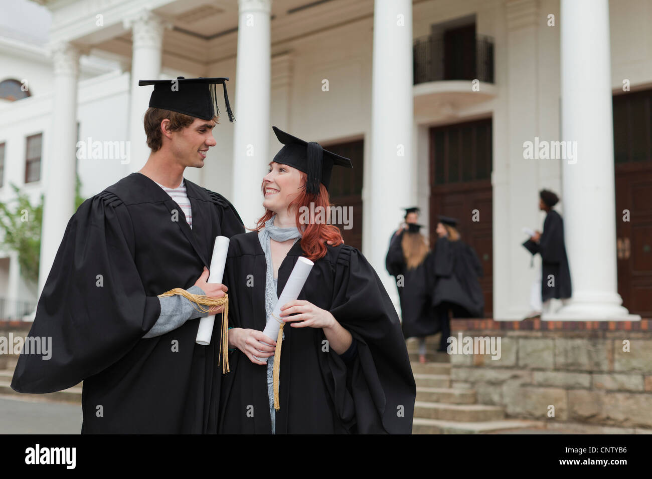 Graduates with their degrees on campus Stock Photo - Alamy