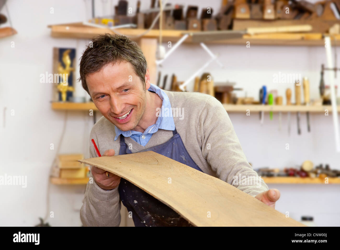 Carpenter examining sheet of wood Stock Photo - Alamy