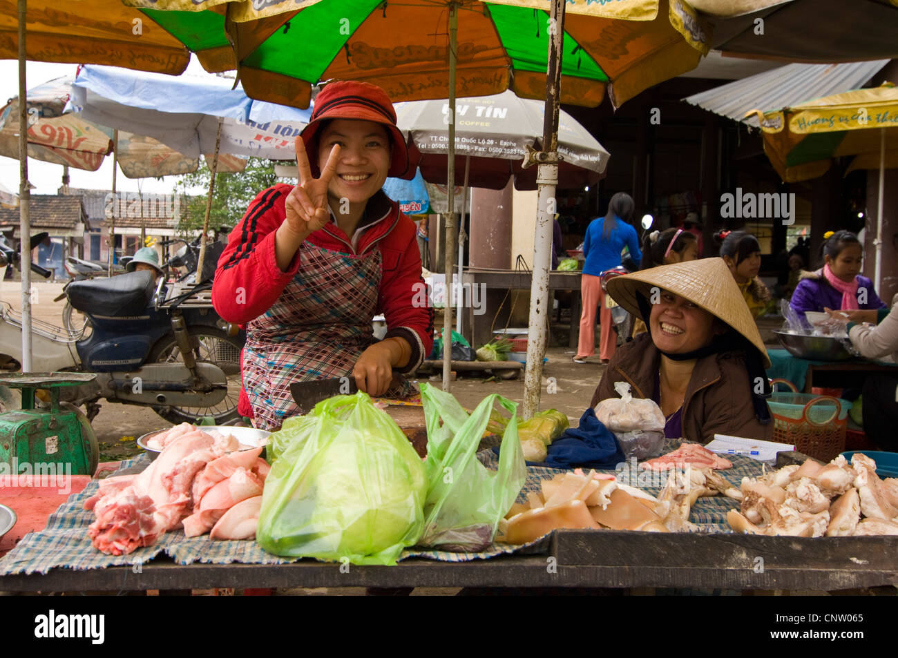 Horizontal portrait two women at a stall selling chunks of meat in a ...