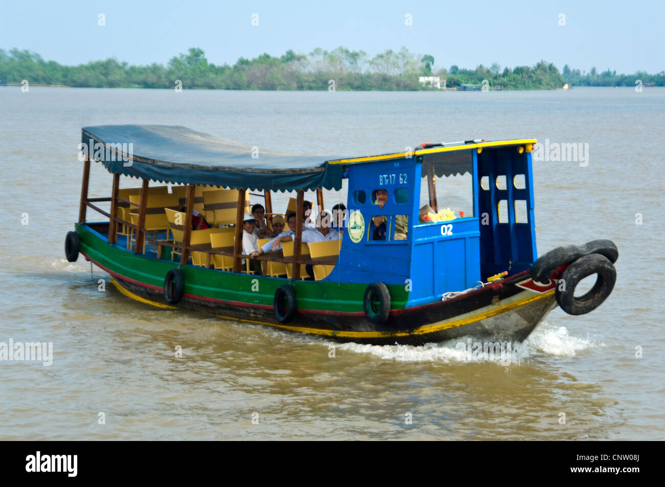 Horizontal view of a small ferry boat with local Vietnamese passengers ...