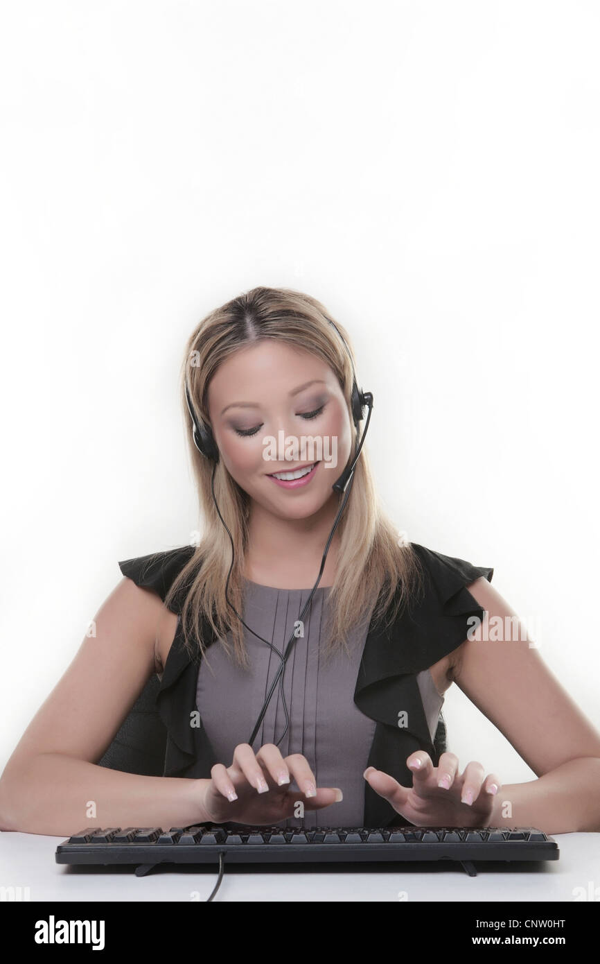 woman at her desk working at a keyboard wearing a headset is she on a ...