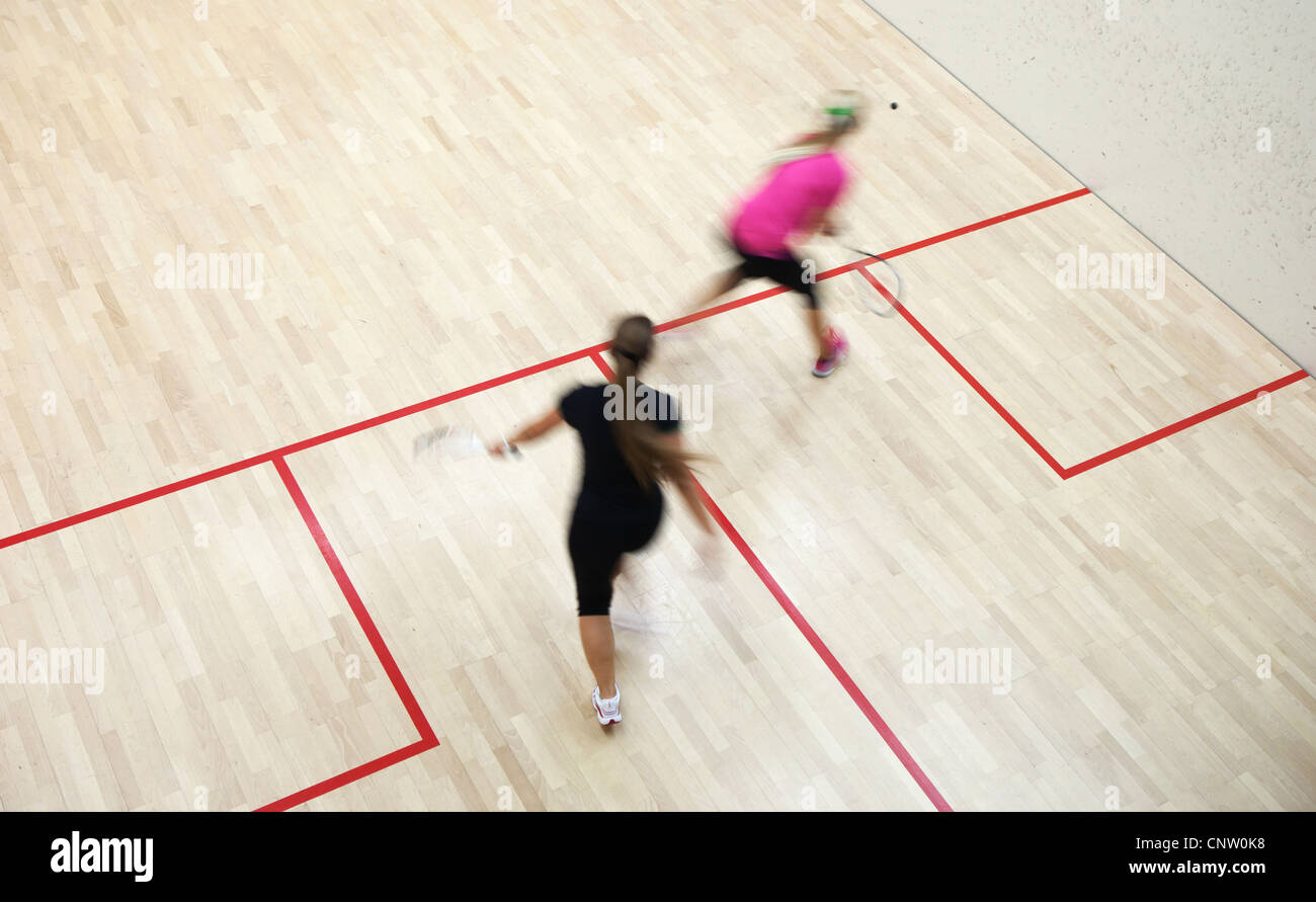 Two female squash players in fast action on a squash court (motion ...