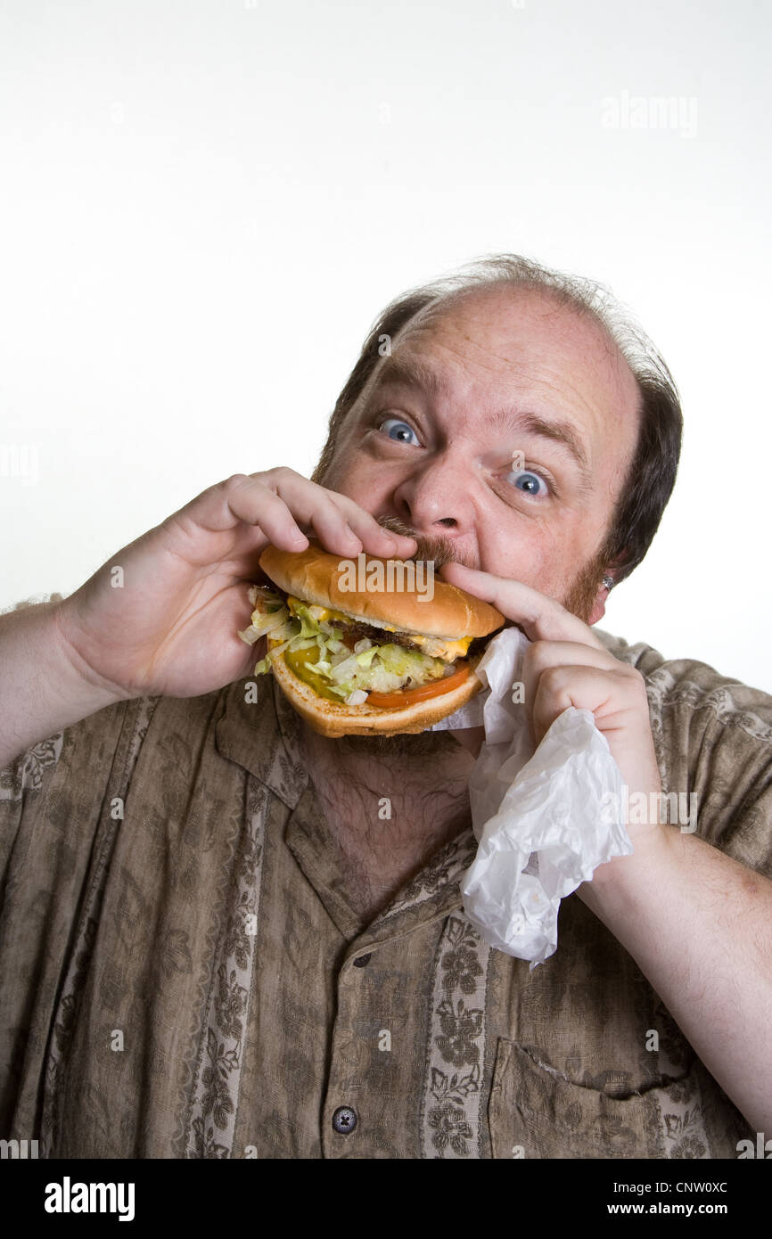 Overweight man in mid forties eating fast food Stock Photo - Alamy