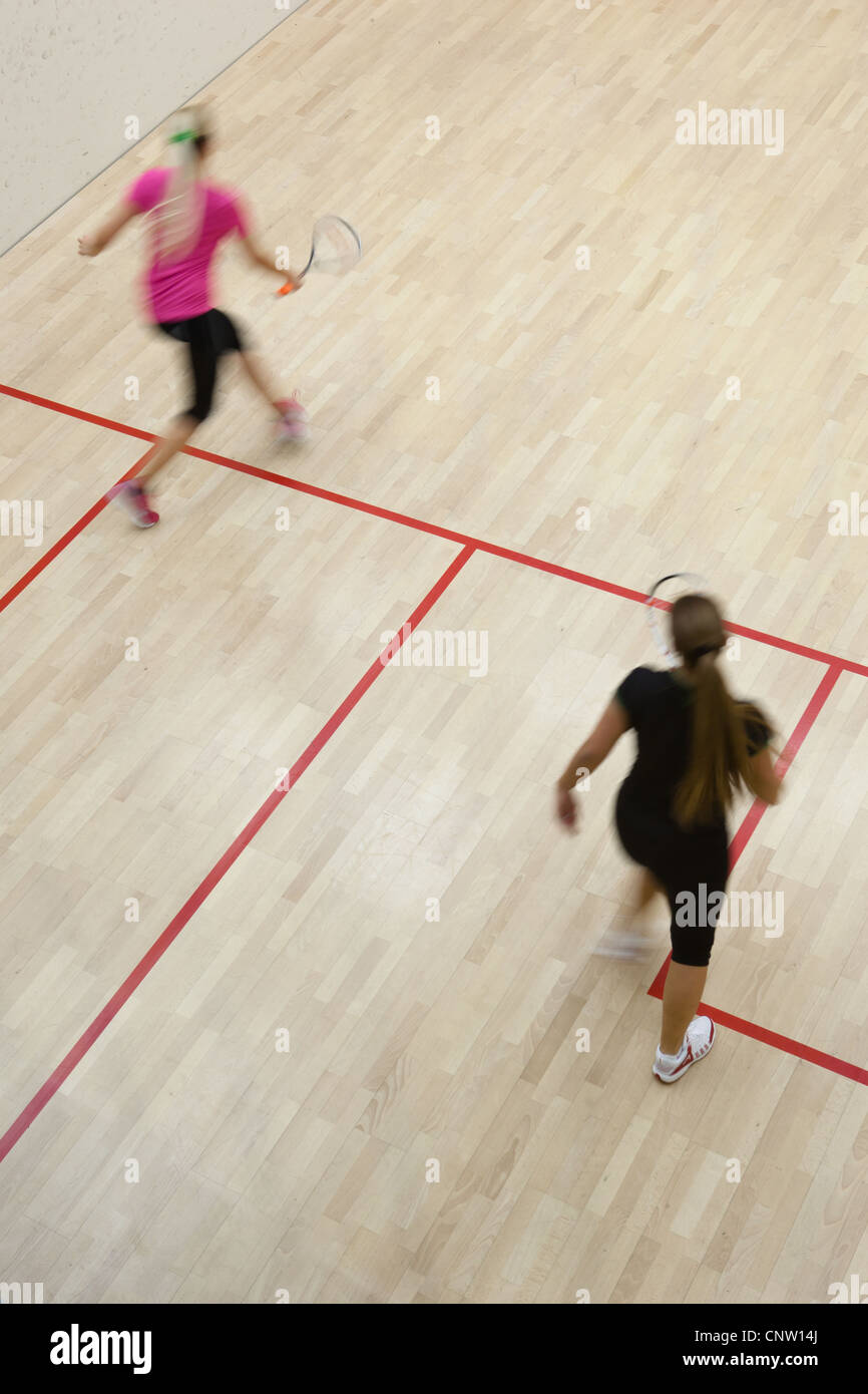 Two female squash players in fast action on a squash court (motion ...