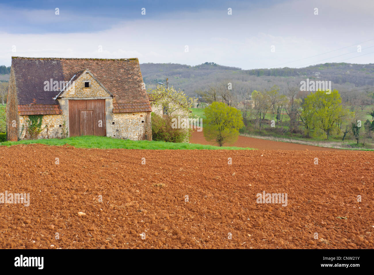 French farm barn and rich red soil in the department of Lot in southern ...