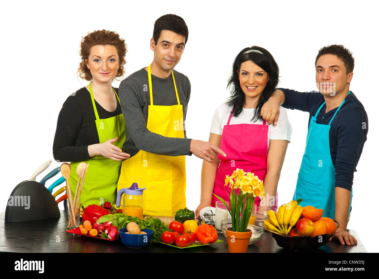 Cheerful team of four chefs standing in a line near table with ...