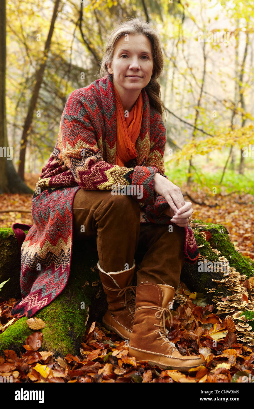 Older woman sitting on stump in forest Stock Photo - Alamy