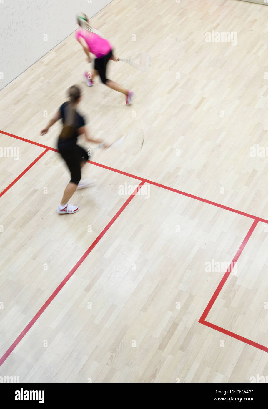 Two female squash players in fast action on a squash court (motion ...