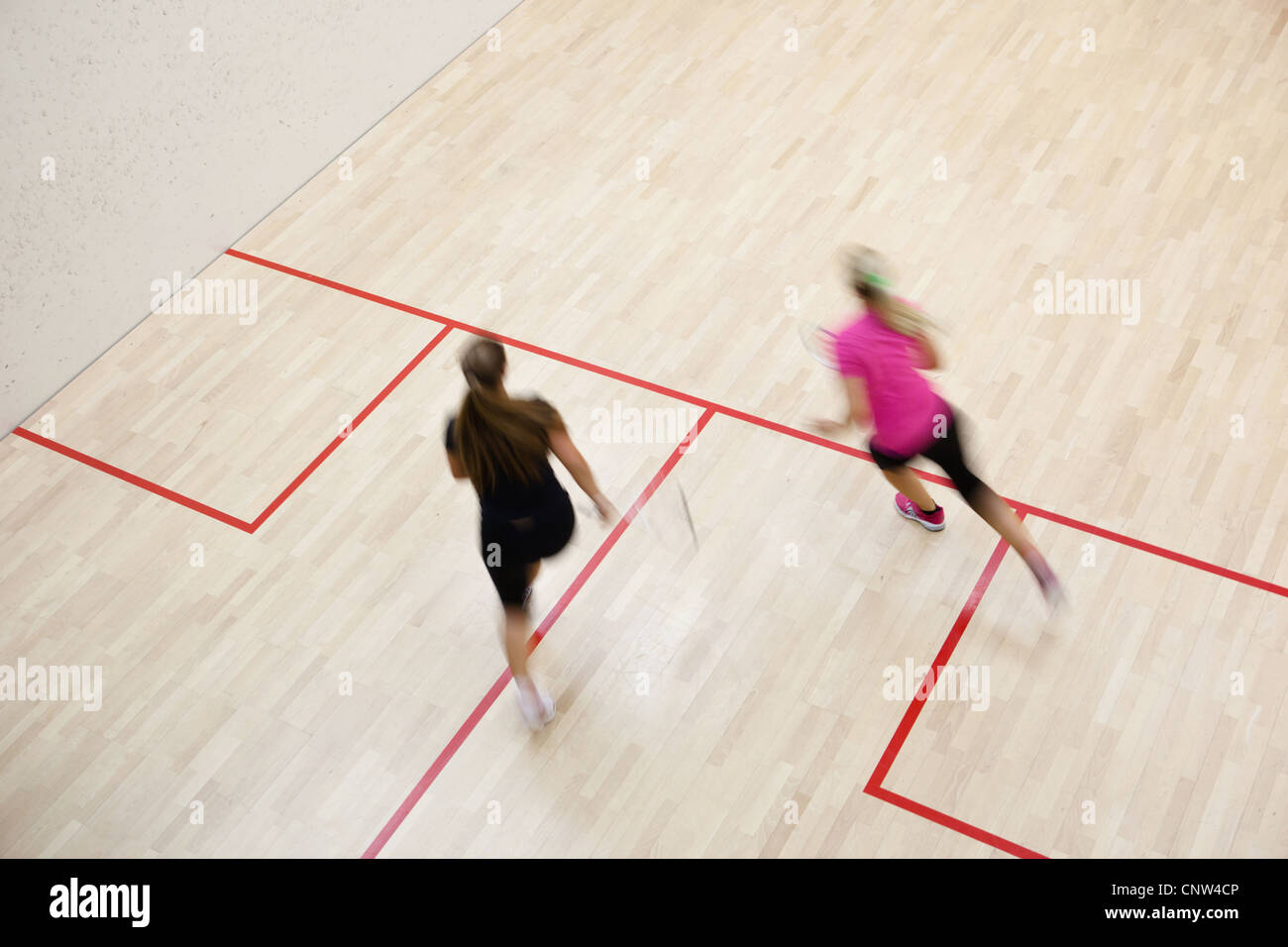 Two female squash players in fast action on a squash court (motion ...