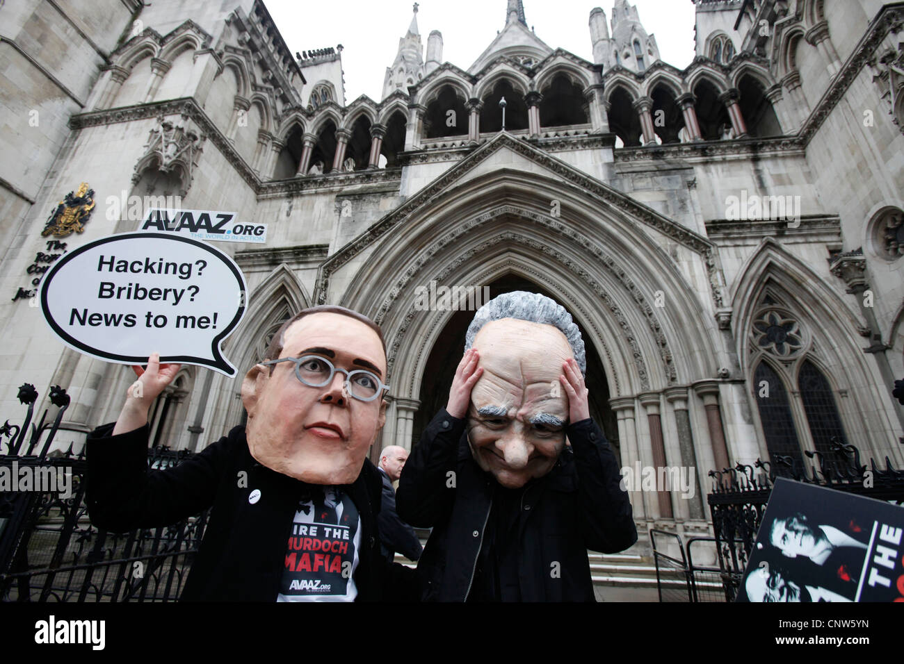 Protesters wearing masks of James Murdoch (L) and his father Rupert (R ...