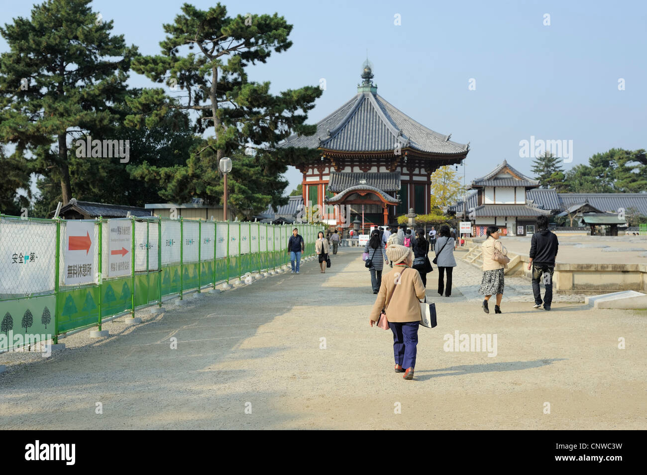 Japanese people walking along construction site barrier at Kofukuji ...