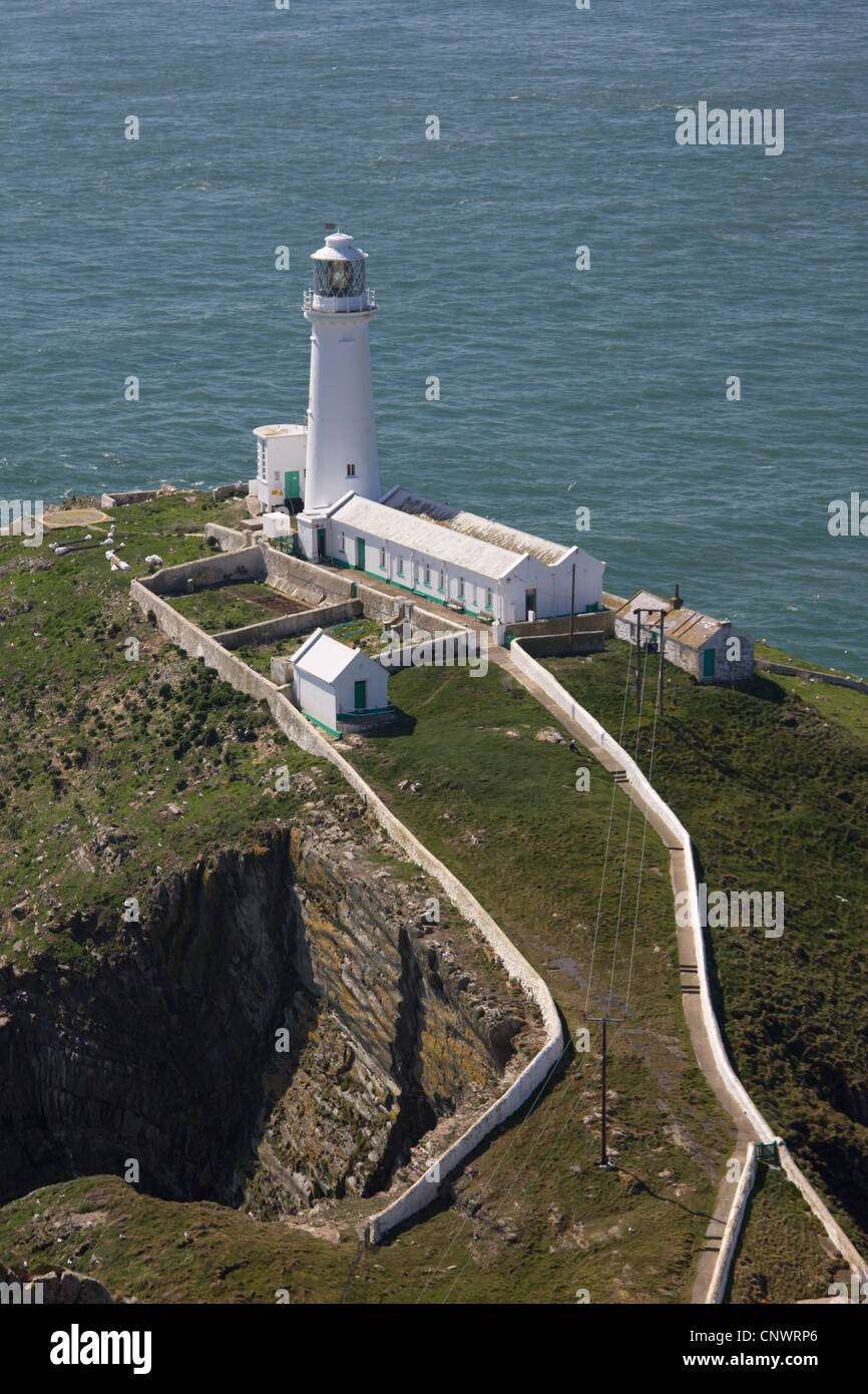 Looking down the steep cliff at South Stack island lighthouse and walls ...
