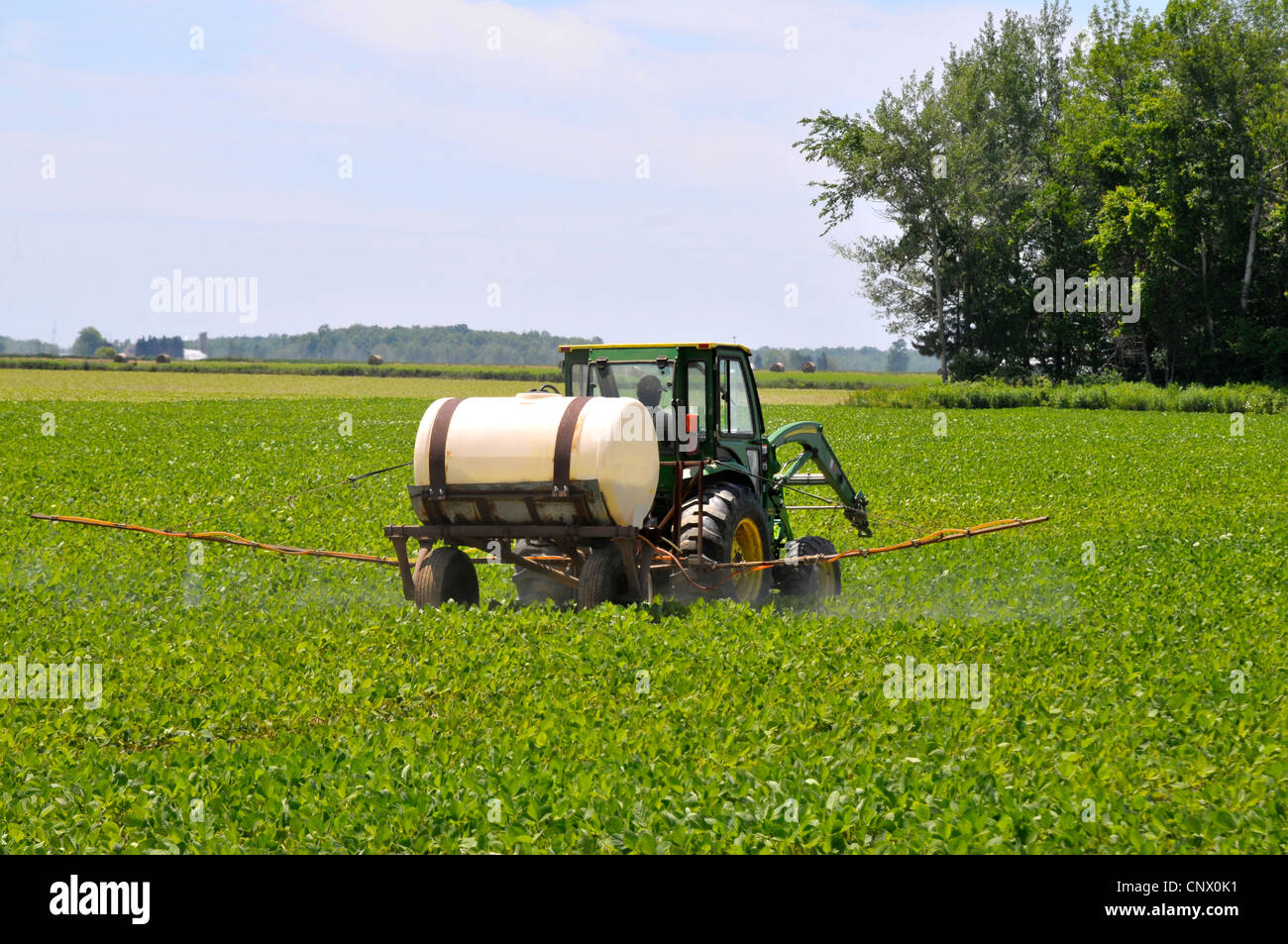 Tractor working farm field spraying soybeans near Croswell Michigan ...