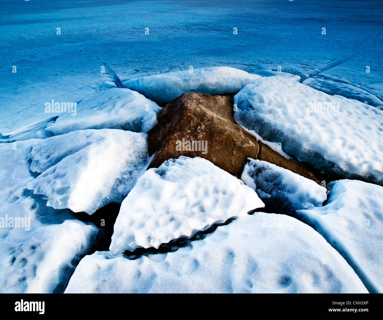 A boulder breaking through ice on a frozen lake in Norway Stock Photo ...