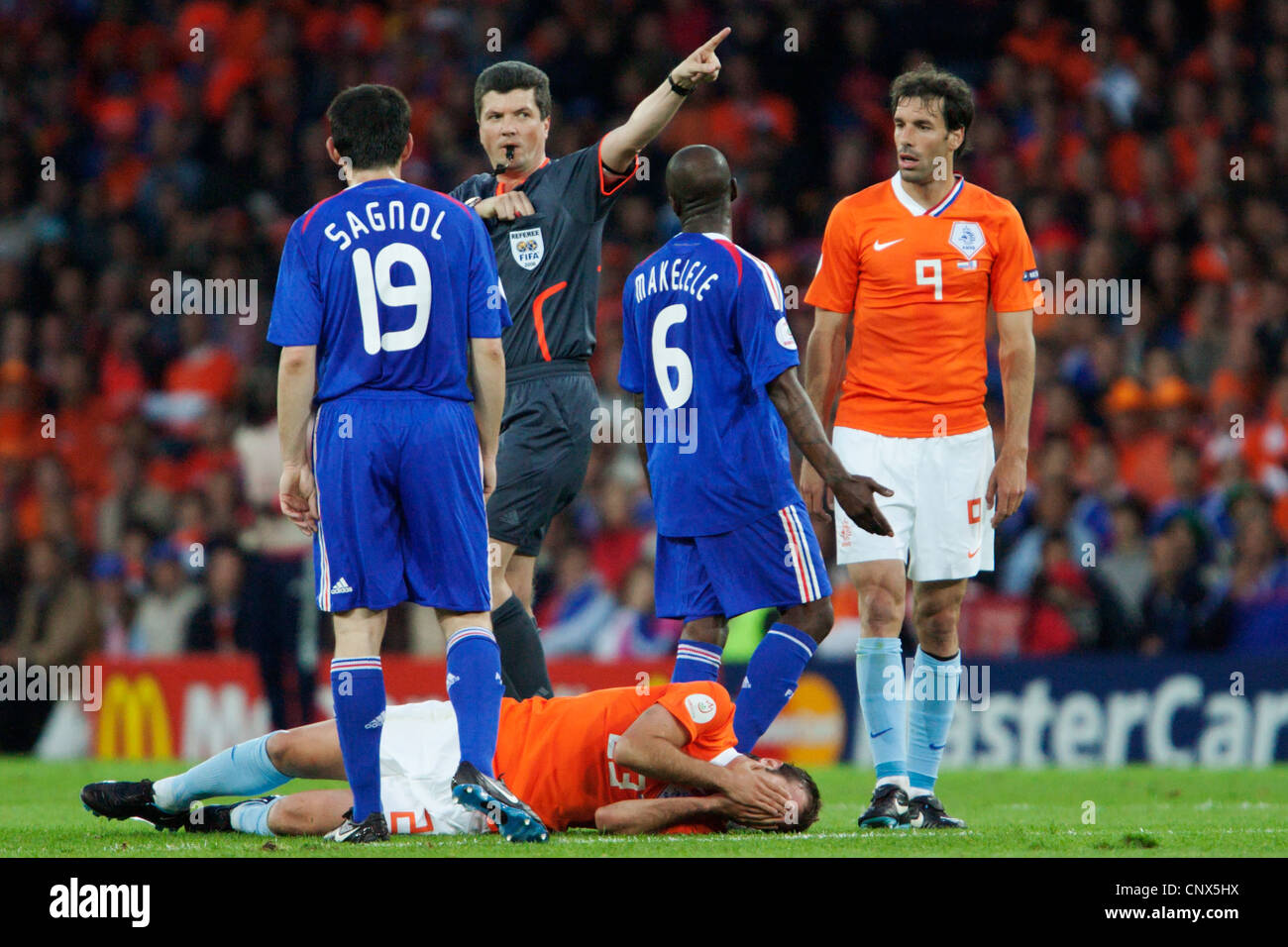 Referee Herbert Fandel reaches for a yellow card to book Claude ...
