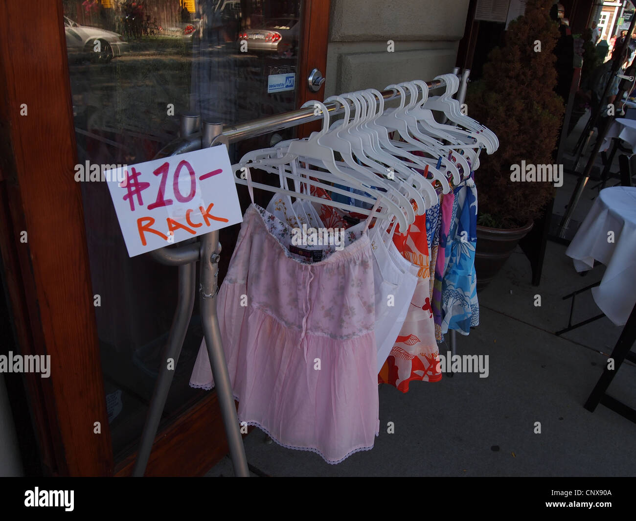 Tank tops on sale for $10 hang on a clothing rack outside of a shop in ...