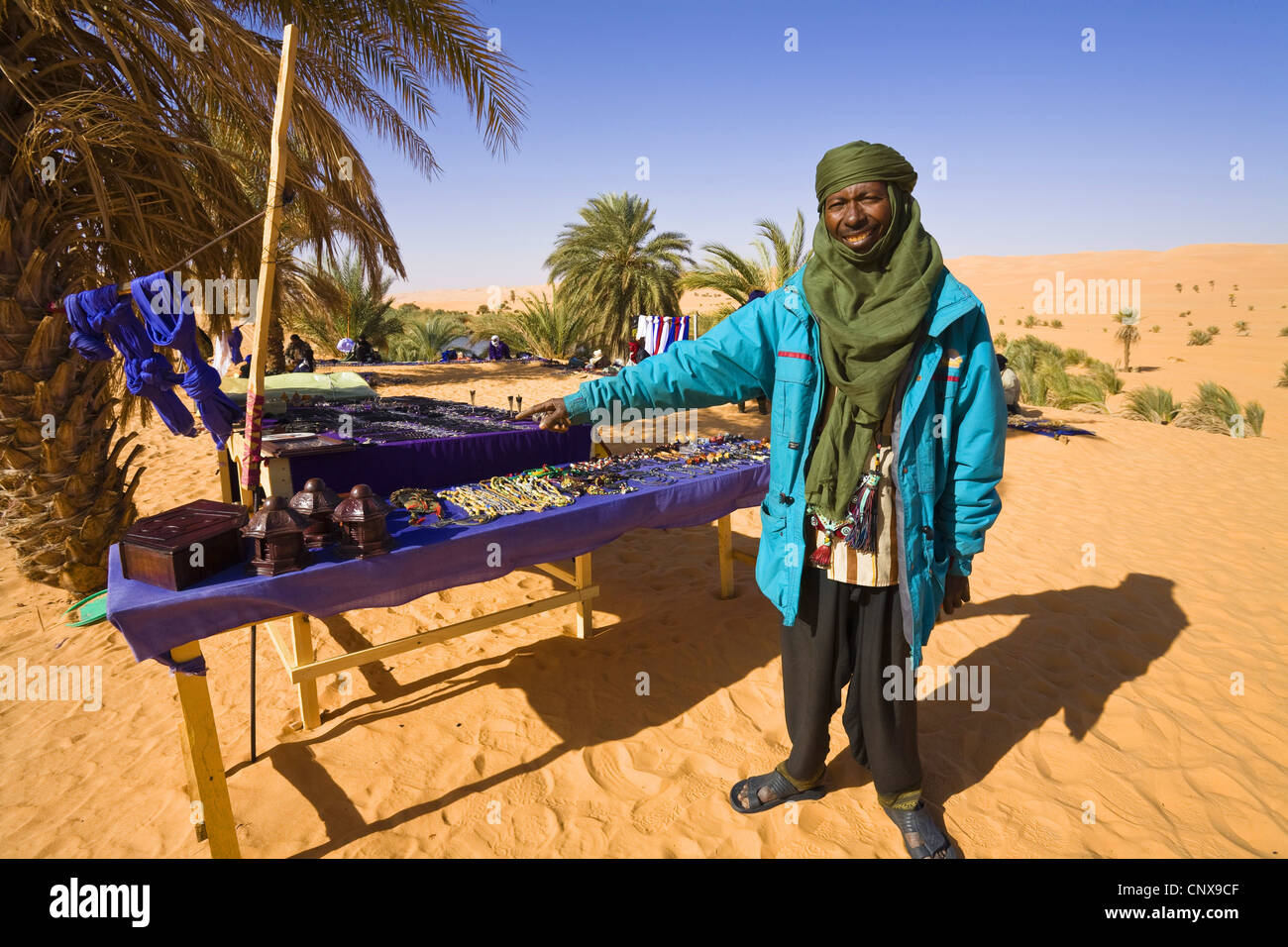 Tuareg trader selling souvenirs at the oasis Um el Ma in the Libyan ...