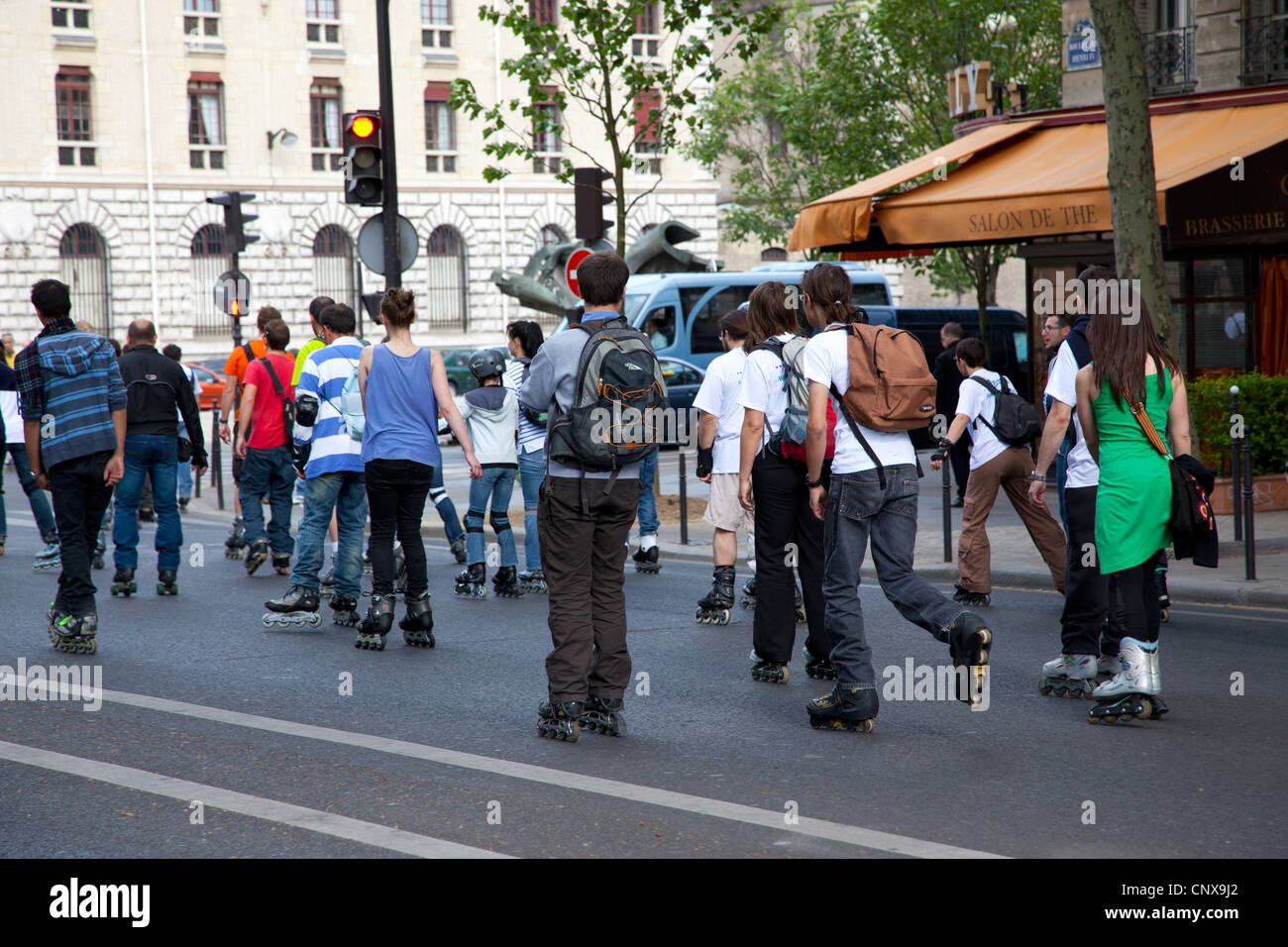 Rollerbladers passing along a street in Paris on a Sunday afternoon ...