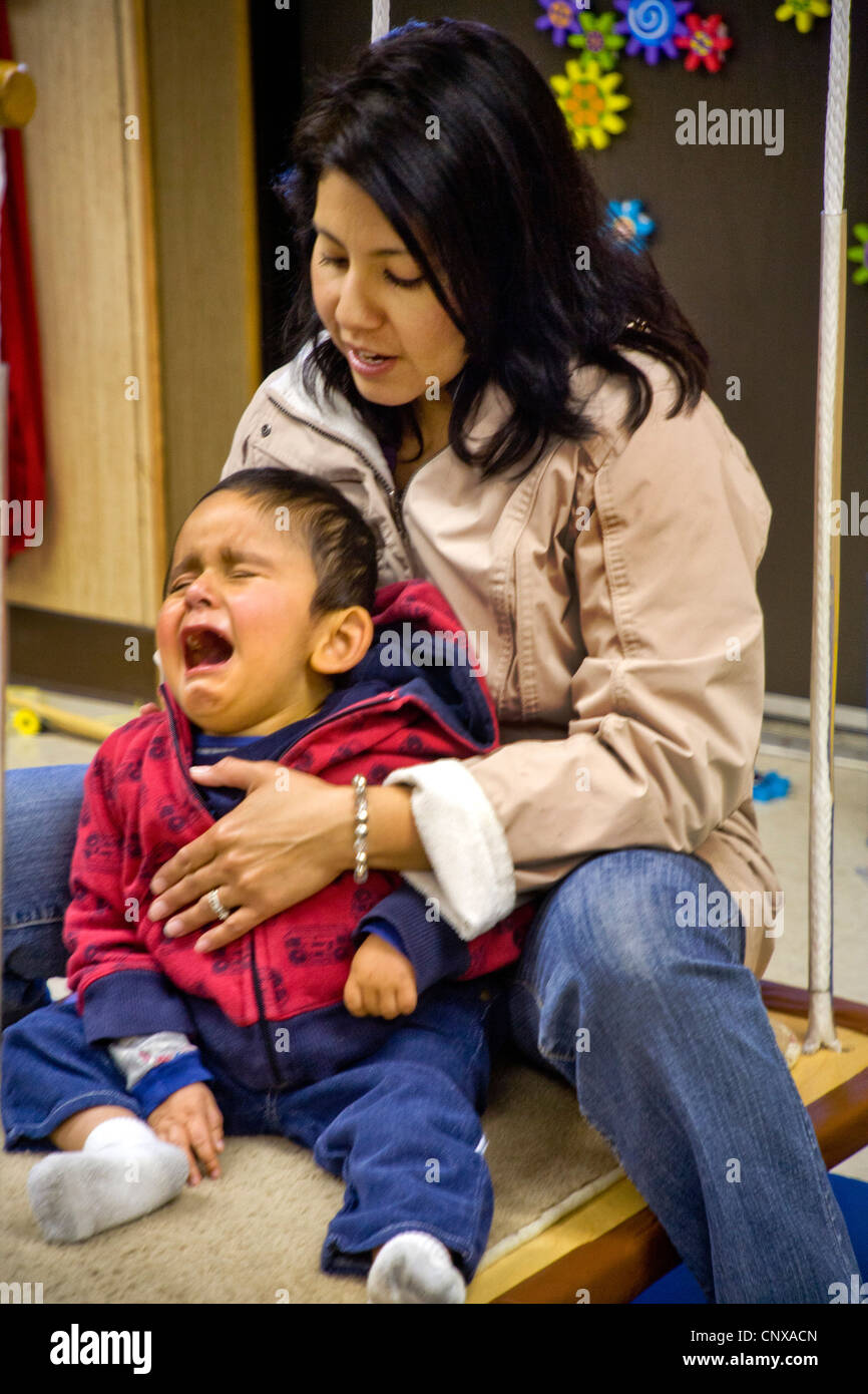 A Hispanic teacher comforts a disoriented frightened vision-impaired ...