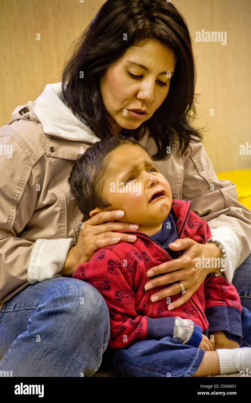 A Hispanic teacher comforts a disoriented frightened vision-impaired ...