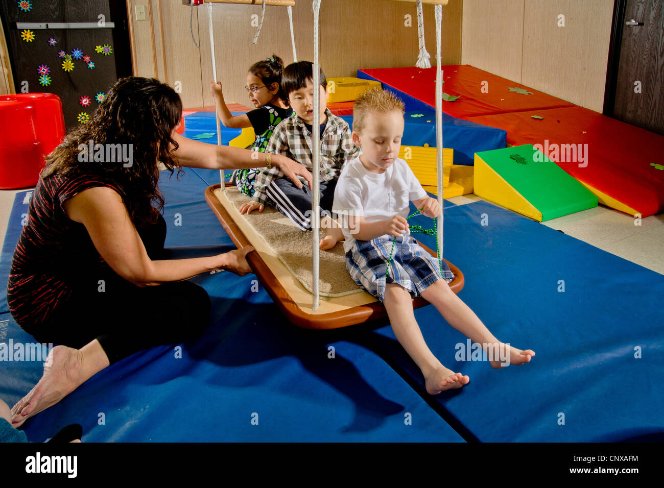 Blind and vision-impaired children ride a swing to improve their ...