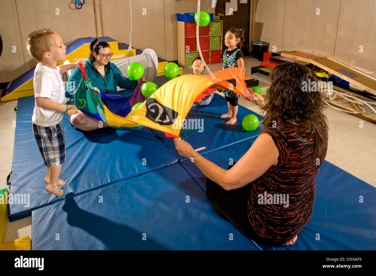 Teachers and visually-impaired students wave a parachute to promote ...