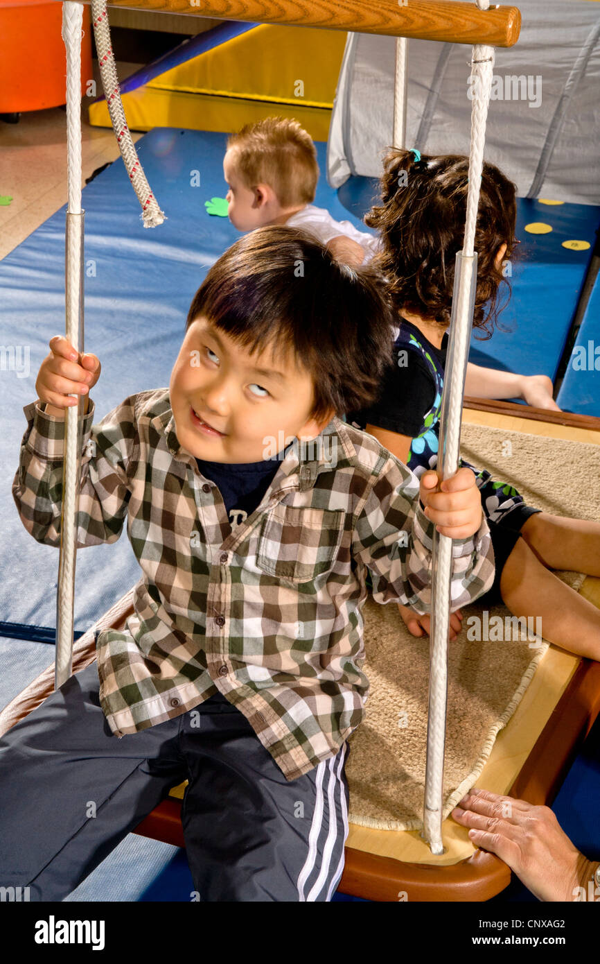 Blind and vision-impaired children ride a swing to improve their ...