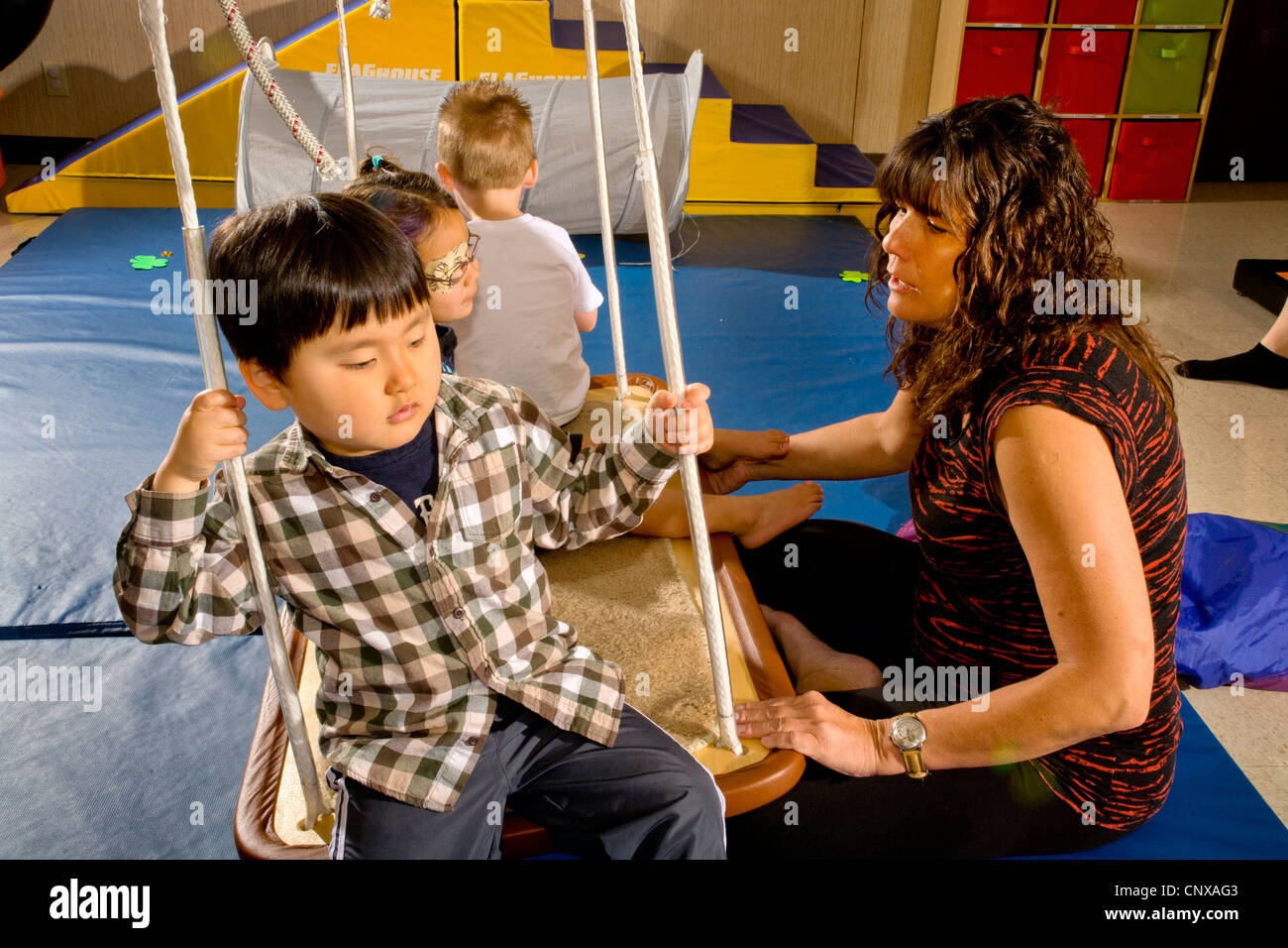 Blind and vision-impaired children ride a swing to improve their ...