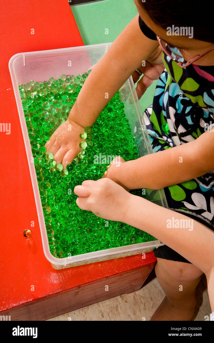 Blind children children feel green gel marbles to improve their tactile ...
