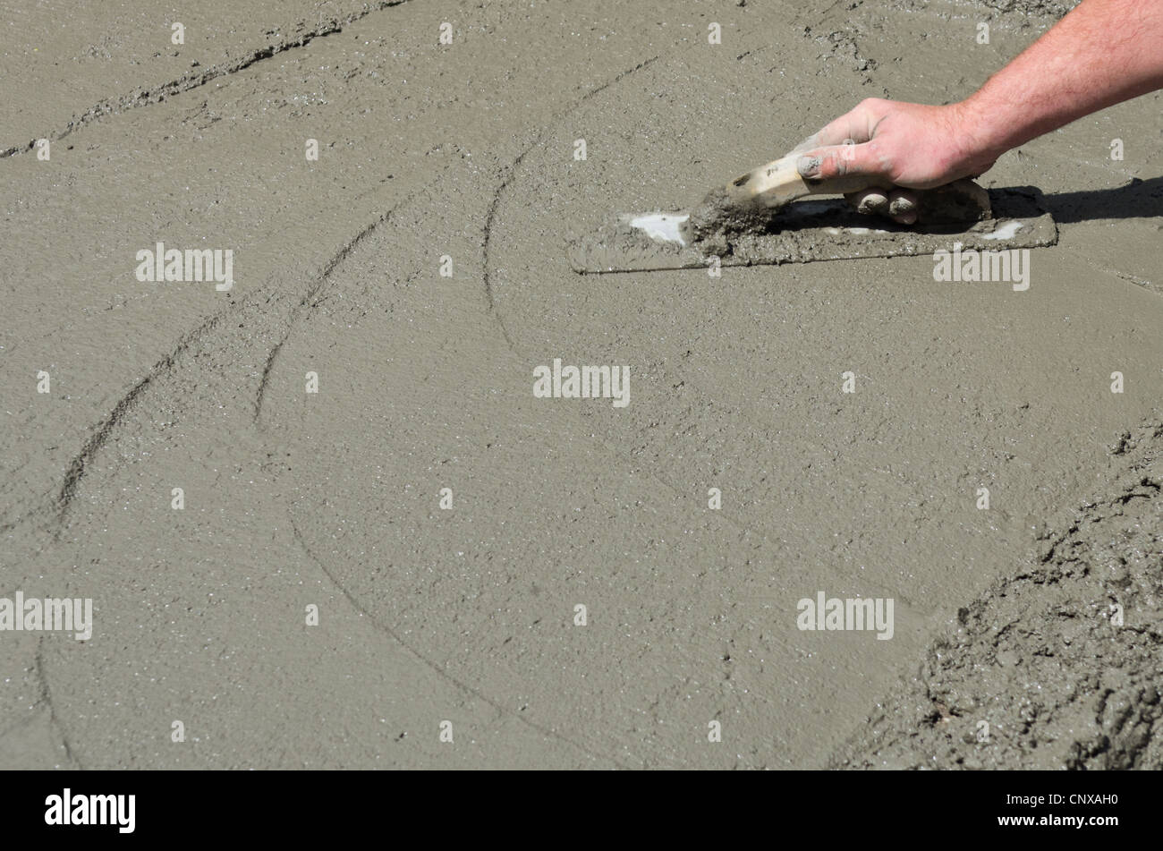 A mason hand finishes a newly poured concrete floor Stock Photo - Alamy