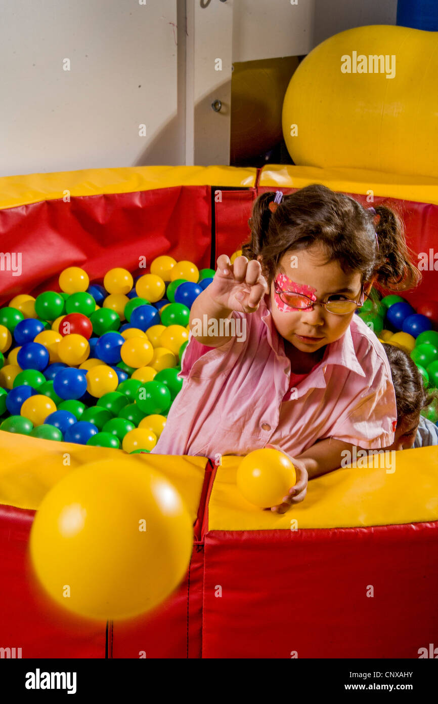 Partially blind girl toss plastic balls during an occupational skills ...